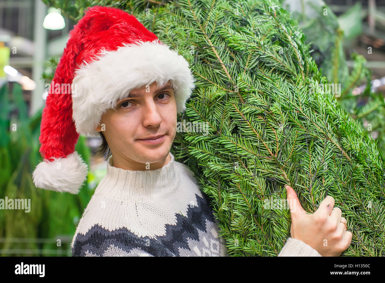 Man in Santa hat buying christmas tree and and showing thumbs up Stock ...