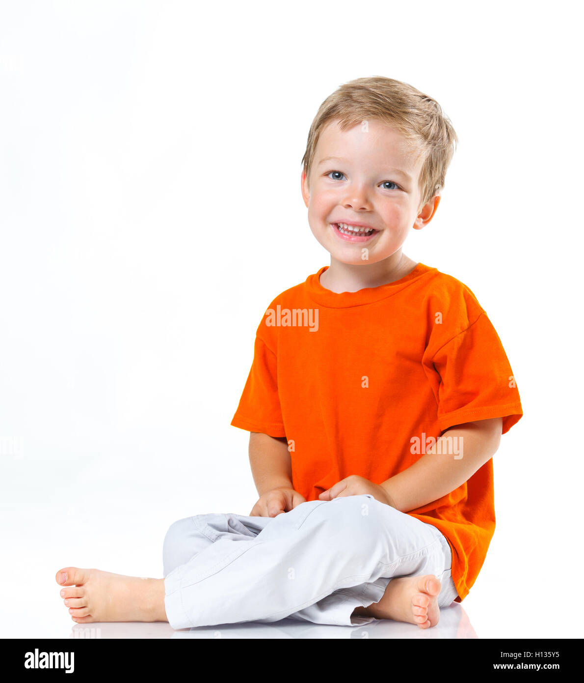 Happy boy sitting on the floor Stock Photo - Alamy