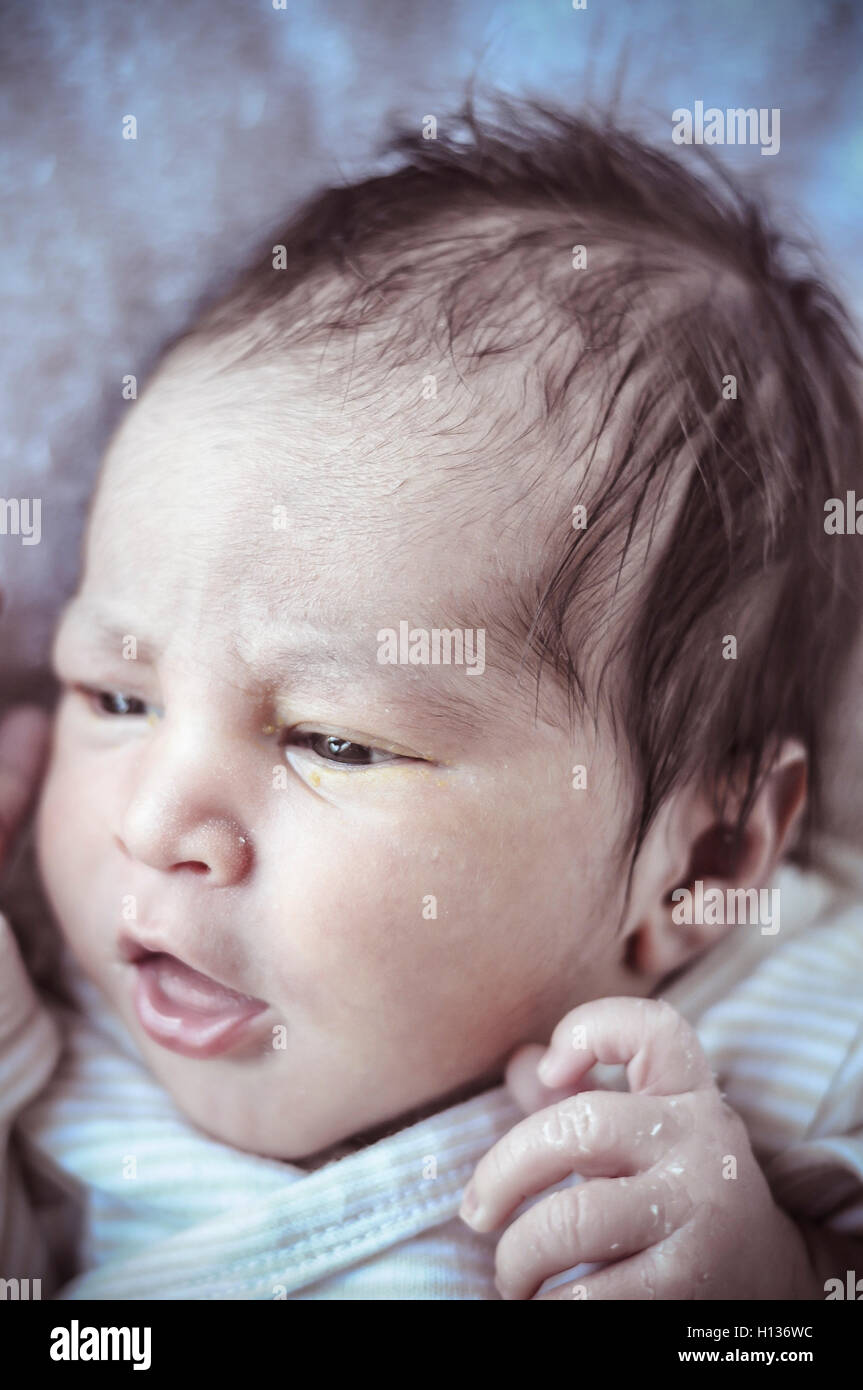 new born baby curled up sleeping on a blanket, multiple expressi Stock ...