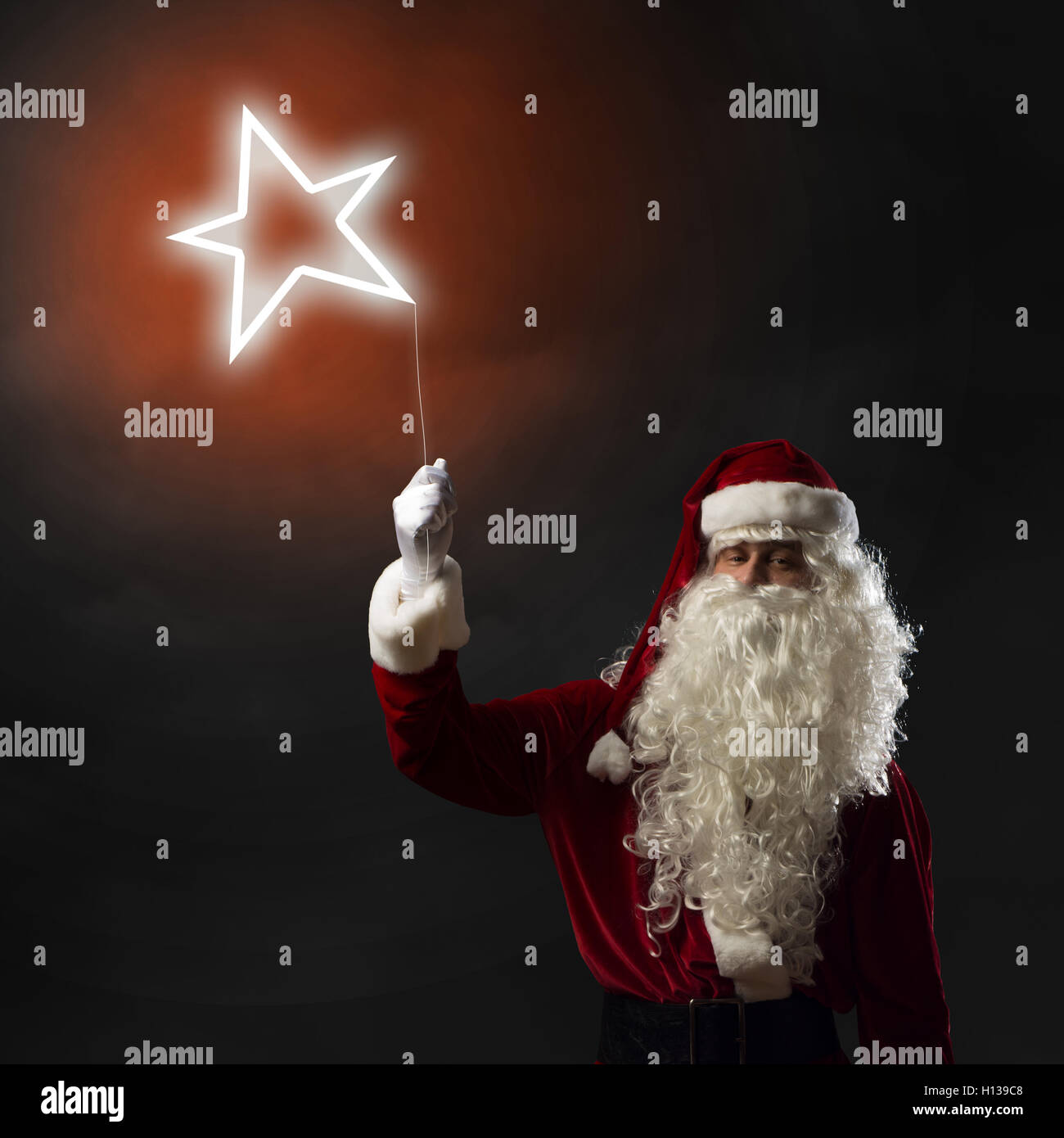 Santa Claus holding a light symbol of the star Stock Photo - Alamy