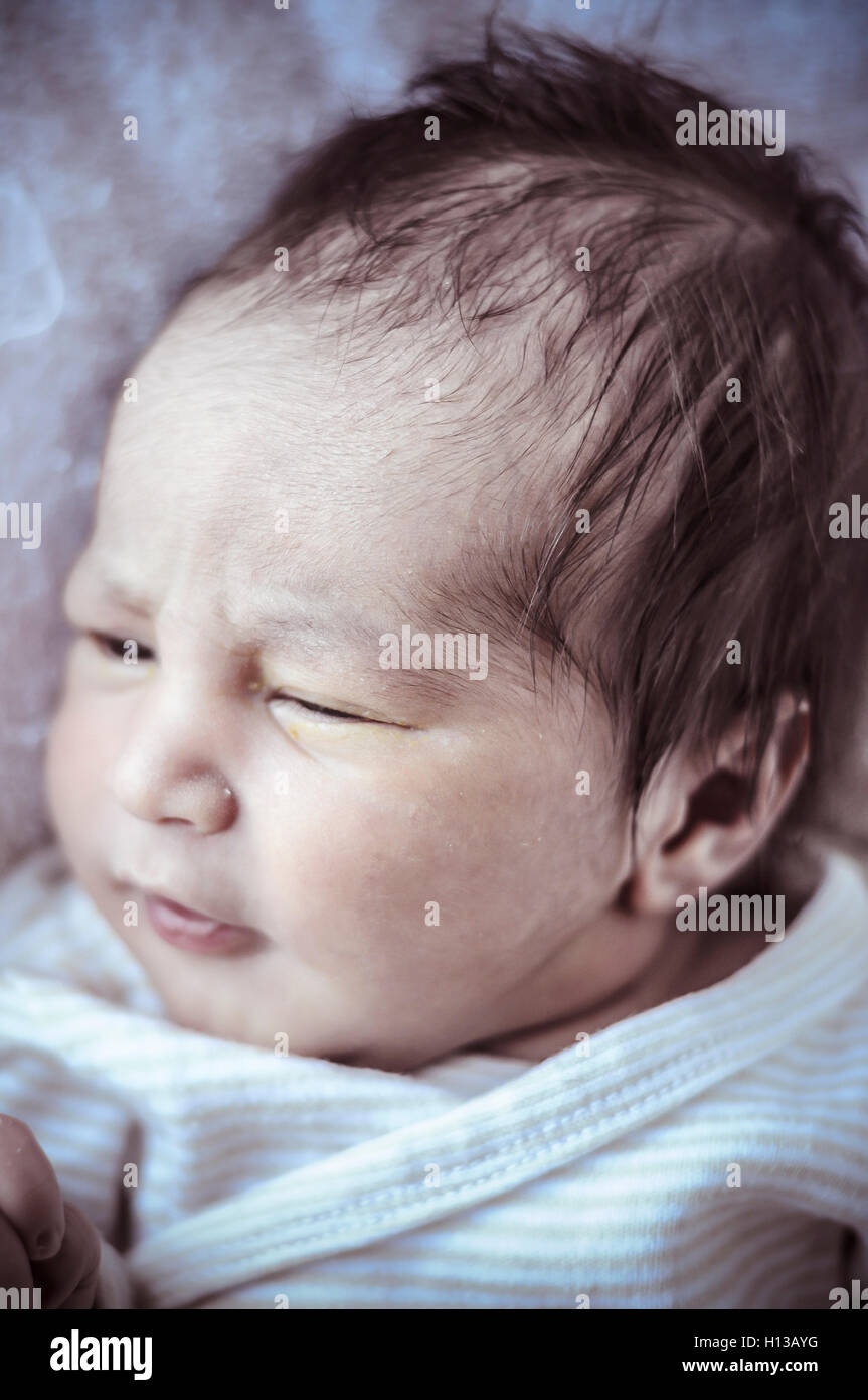 new born baby curled up sleeping on a blanket, multiple expressi Stock ...