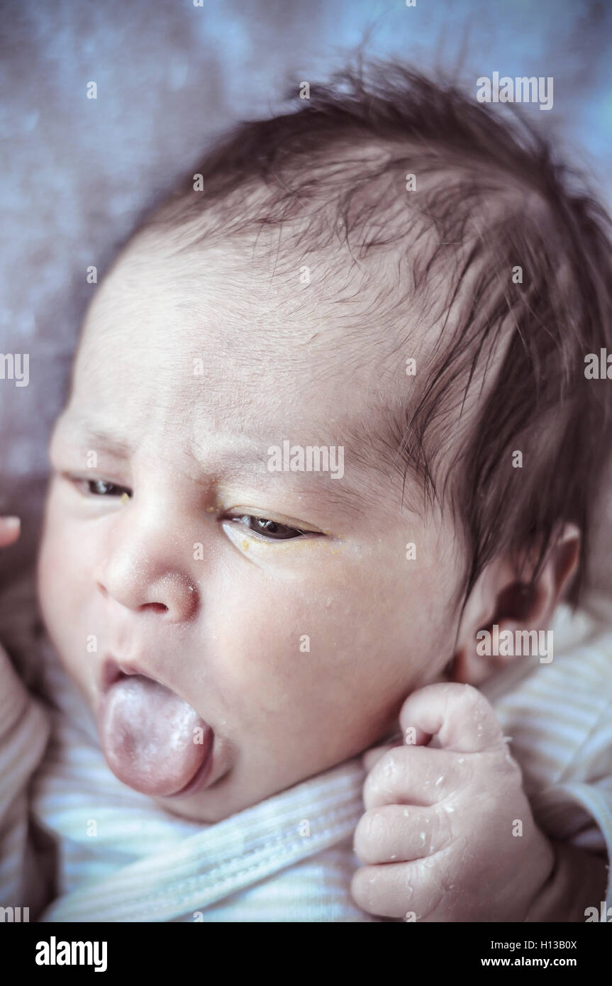 new born baby curled up sleeping on a blanket, multiple expressi Stock ...