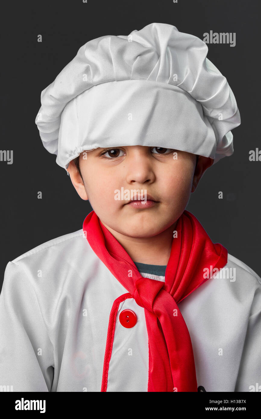 Sad, little boy preparing healthy food on kitchen over grey back Stock ...