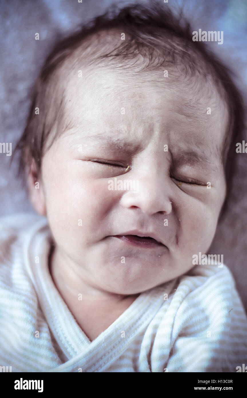 new born baby curled up sleeping on a blanket, multiple expressi Stock ...