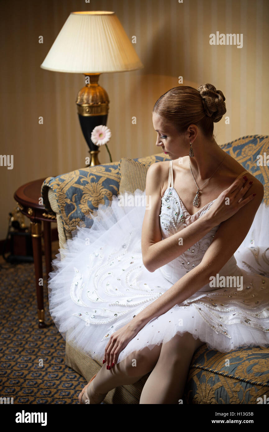 Professional ballet dancer sitting on sofa Stock Photo - Alamy