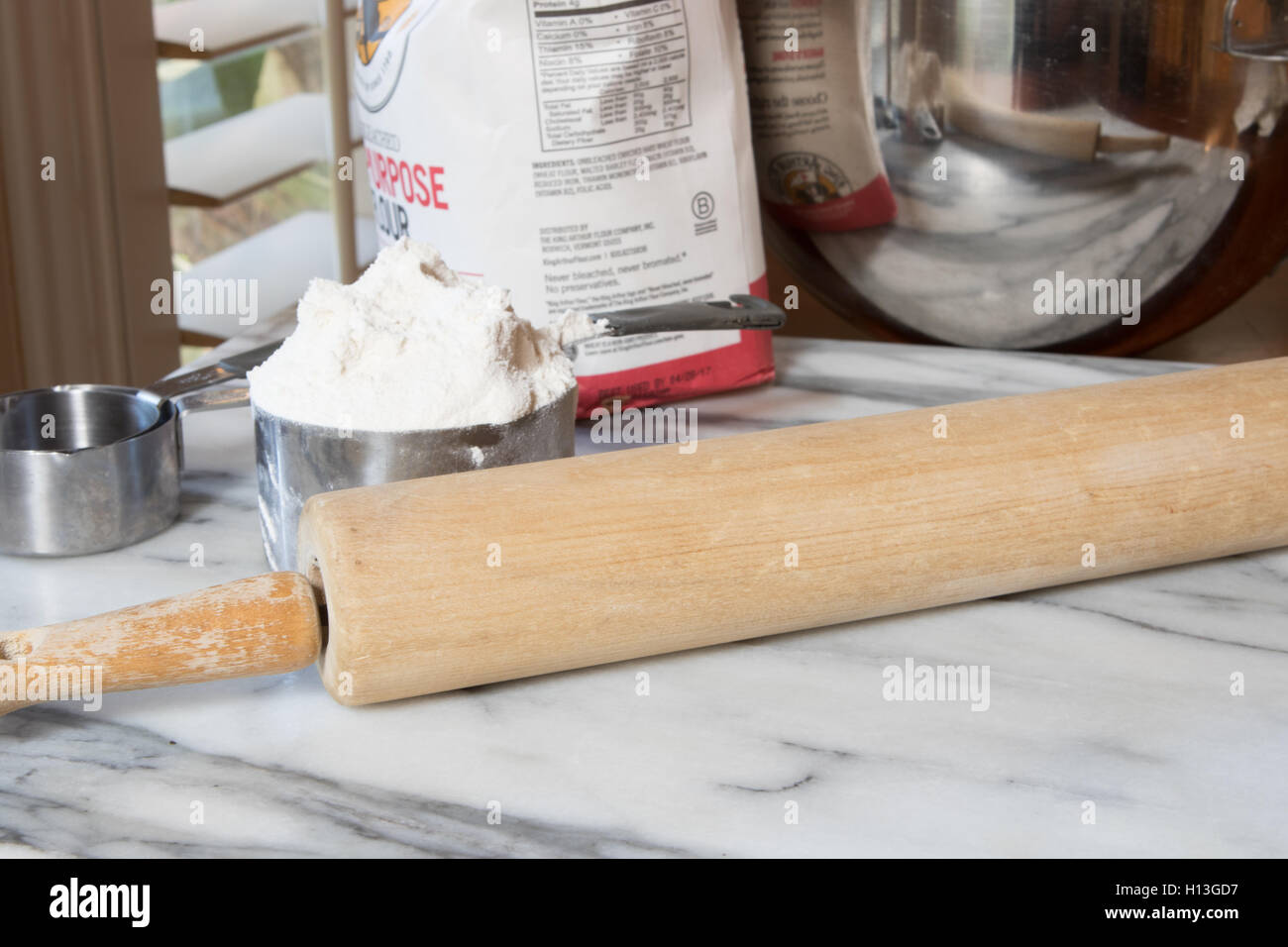 Marble pastry board with measuring cups flour mixing bowl and rolling ...