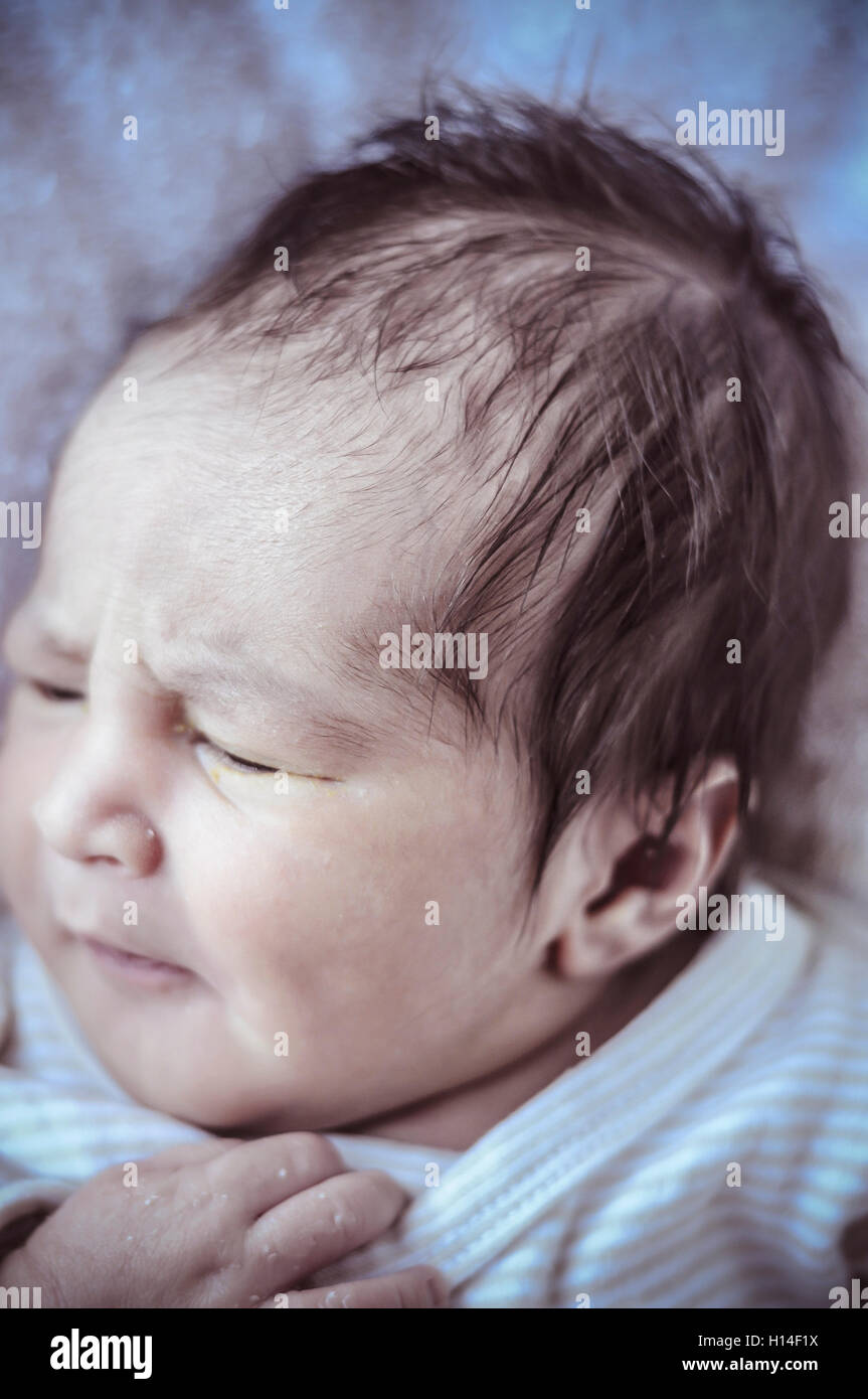 new born baby curled up sleeping on a blanket, multiple expressi Stock ...