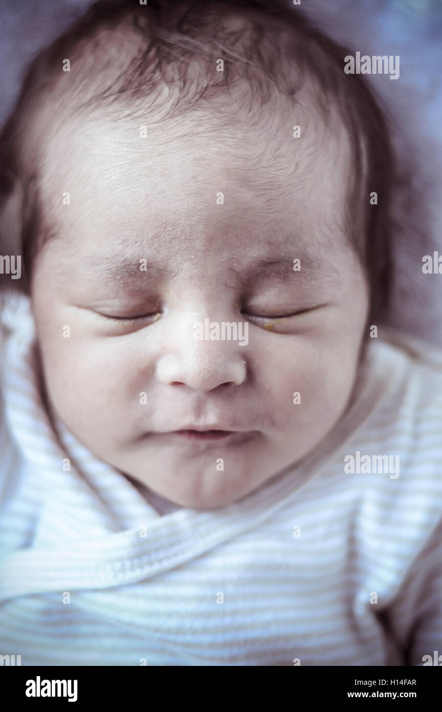 new born baby curled up sleeping on a blanket, multiple expressi Stock ...