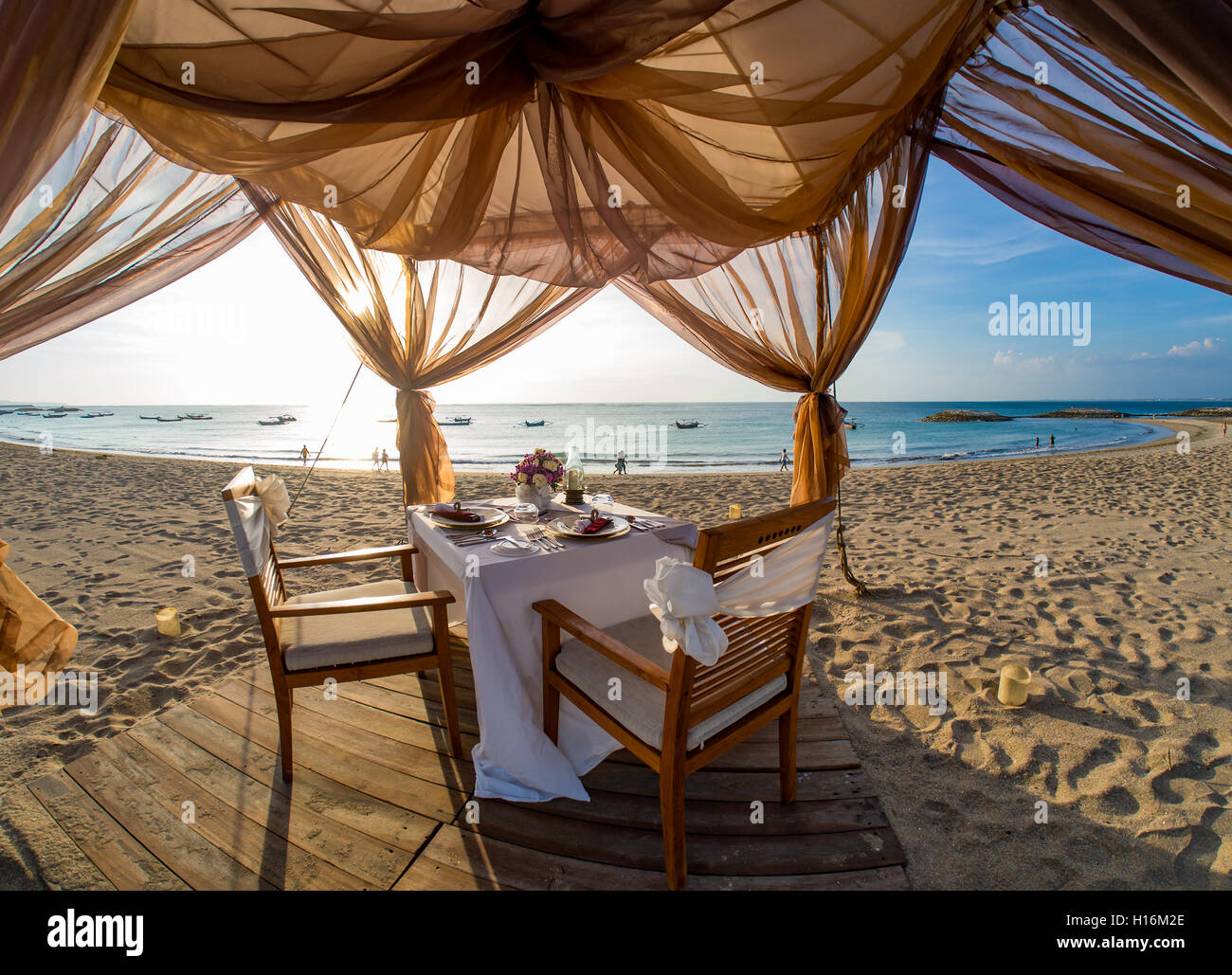 Romantic dinner setting on the beach at sunset Stock Photo - Alamy