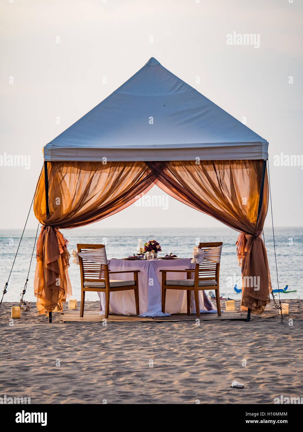 Romantic dinner setting on the beach at sunset Stock Photo - Alamy