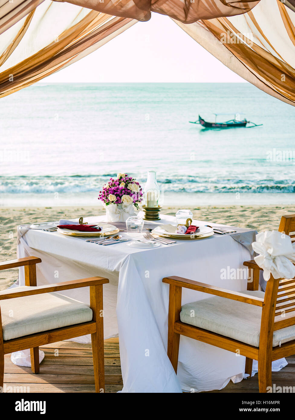 Romantic dinner setting on the beach at sunset Stock Photo - Alamy