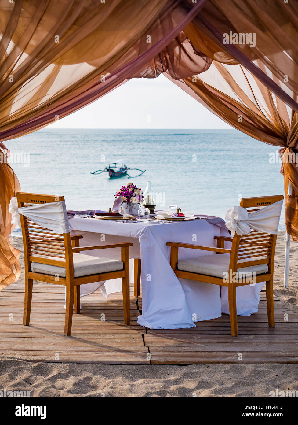 Romantic dinner setting on the beach at sunset Stock Photo - Alamy