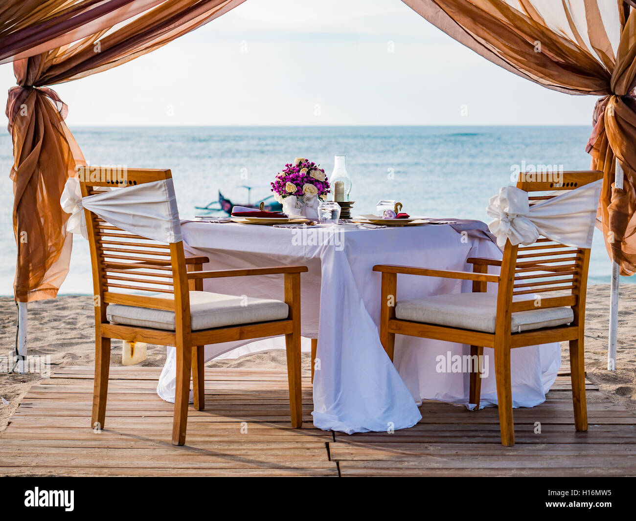 Romantic dinner setting on the beach at sunset Stock Photo - Alamy