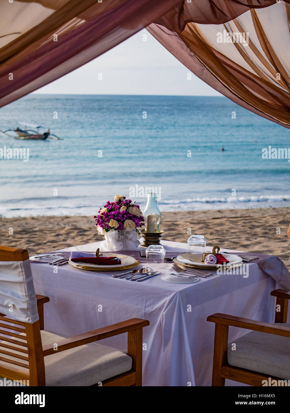 Romantic dinner setting on the beach at sunset Stock Photo - Alamy