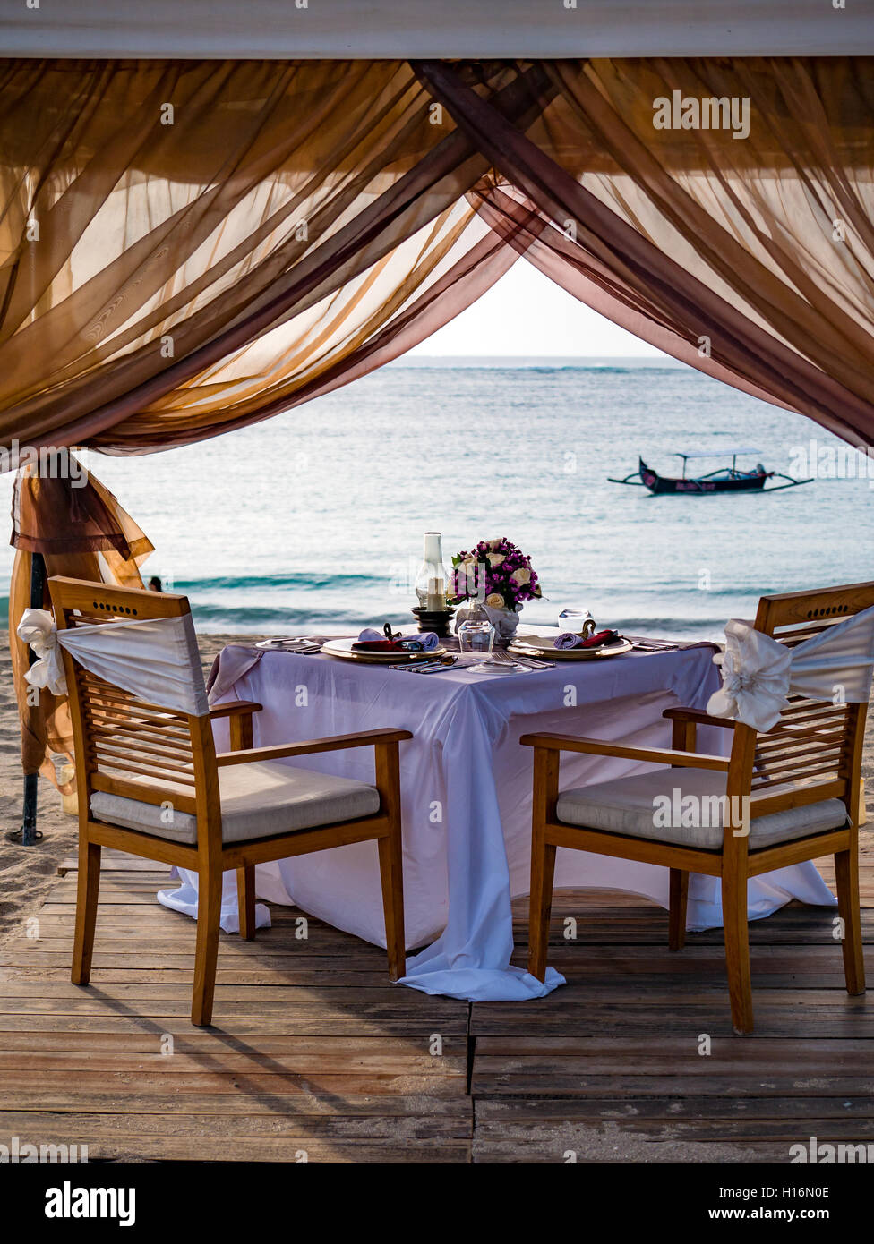Romantic dinner setting on the beach at sunset Stock Photo - Alamy