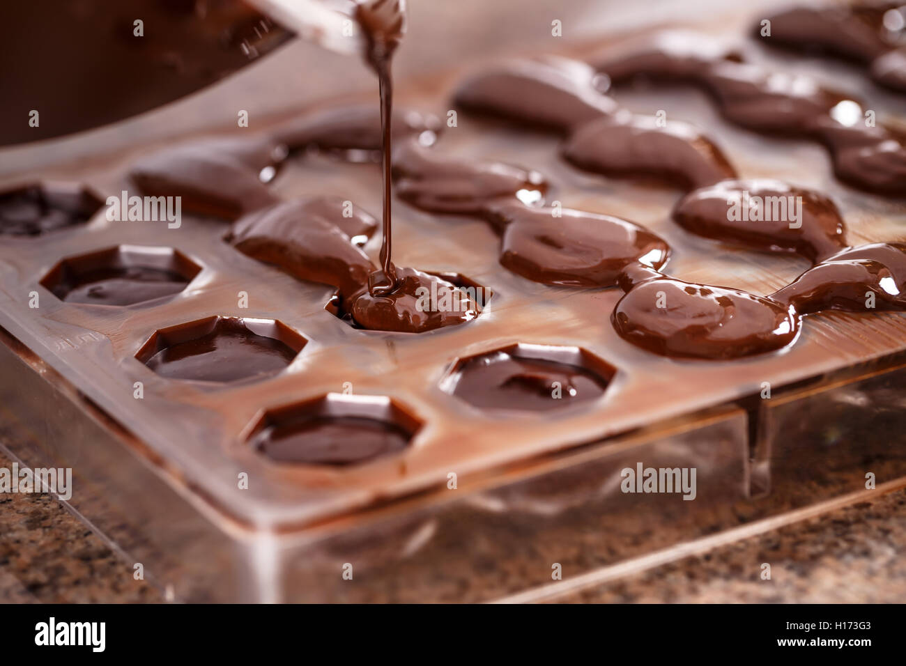 Putting chocolate in mold, make praline Stock Photo - Alamy