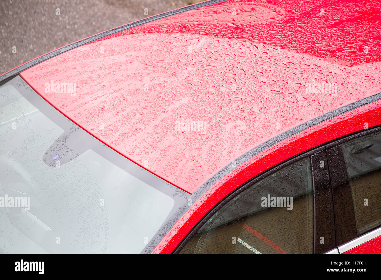 Looking down on a red car roof covered in rain drops Stock Photo - Alamy