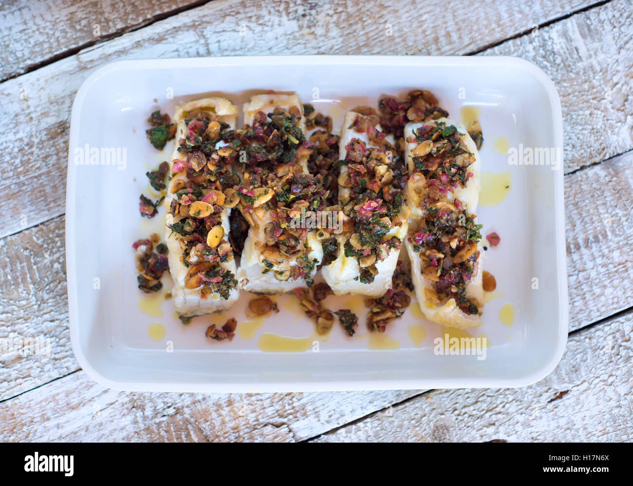 Zander fish fillets in ceramic dishware against wooden table Stock ...
