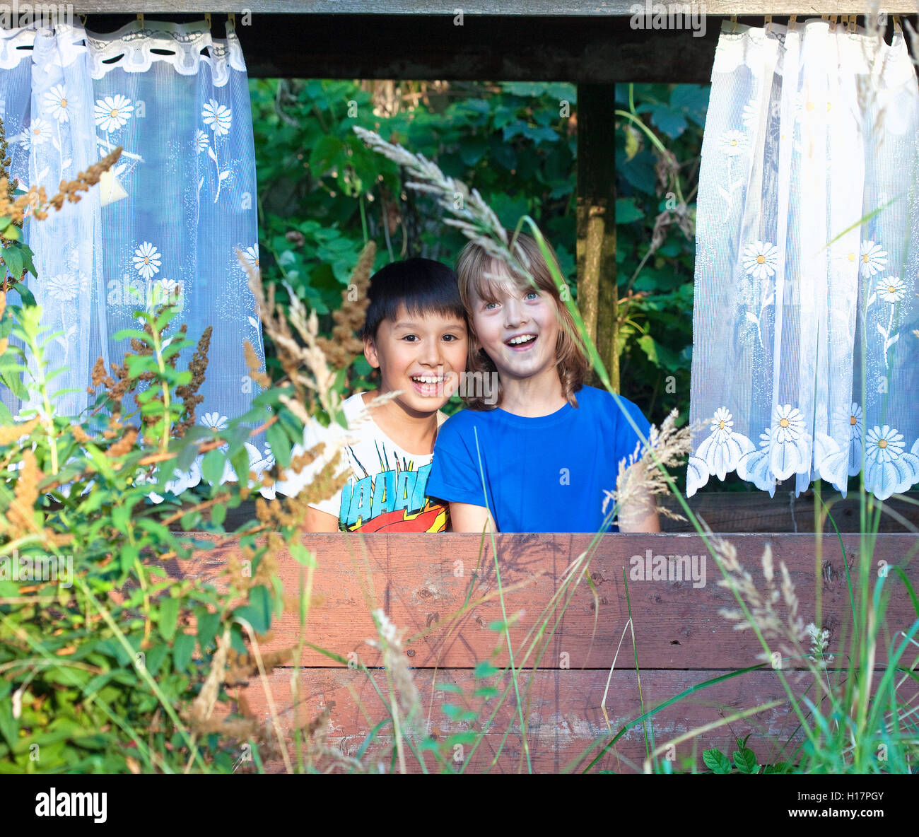 Two Boys Sitting in a Cabin in the Garden Having Fun Stock Photo - Alamy