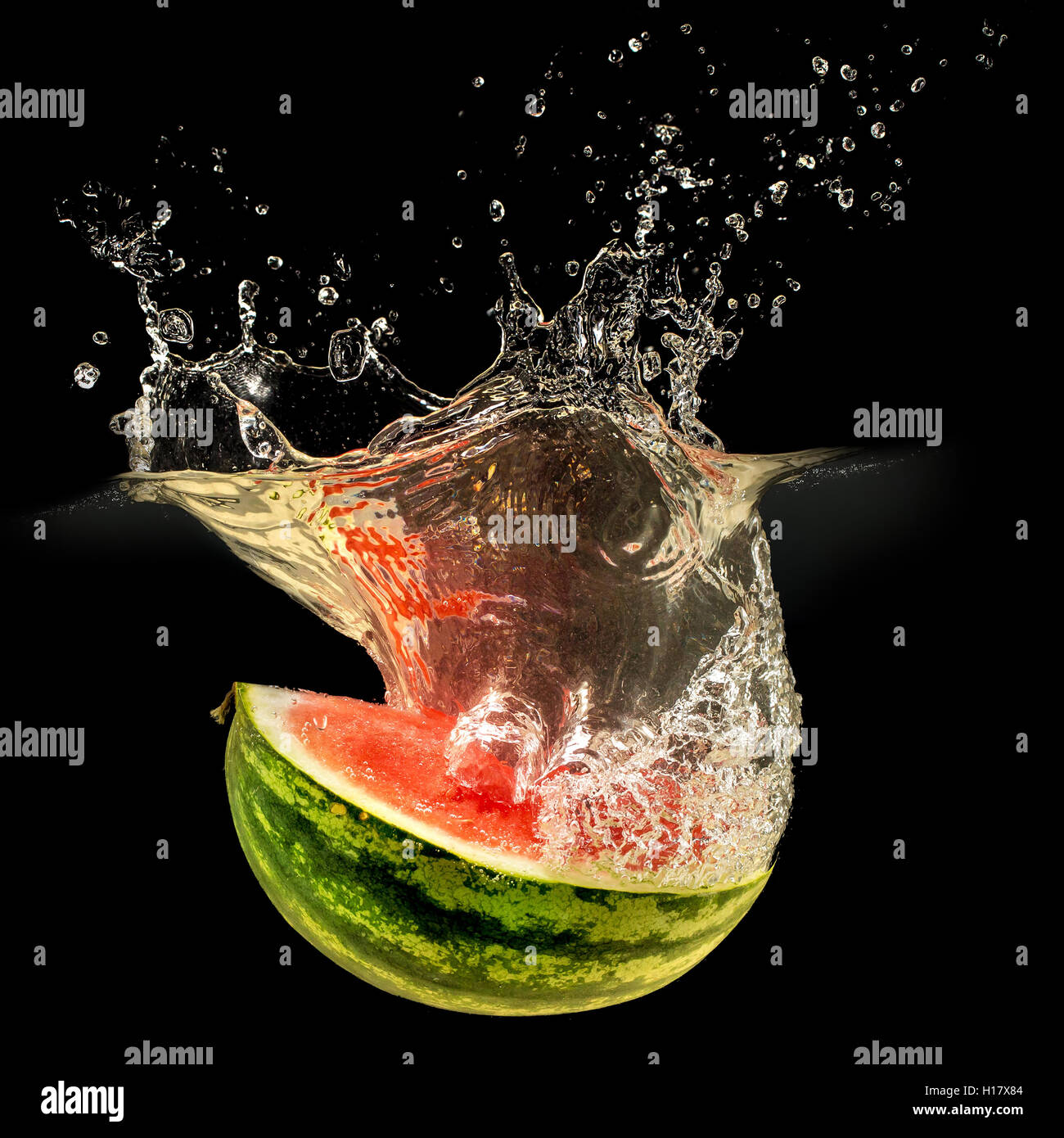 Fresh melon falling in water with splash on black Stock Photo - Alamy