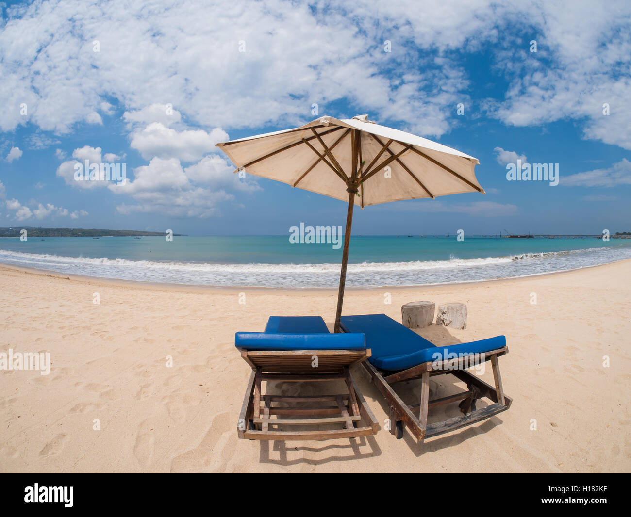 Relaxing couch chairs with parasol on white sandy Beach looking towards ...