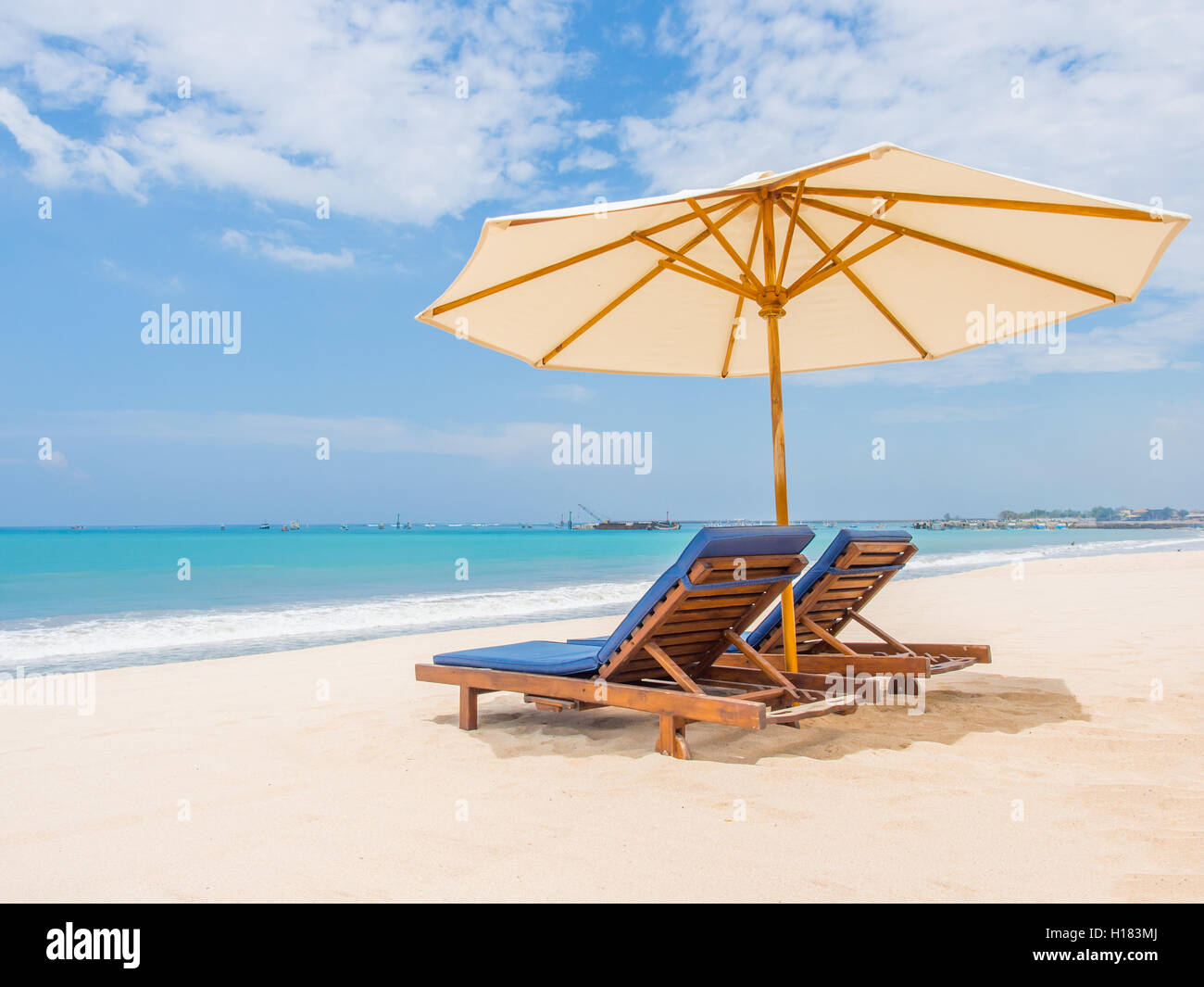 Relaxing couch chairs with parasol on white sandy Beach looking towards ...