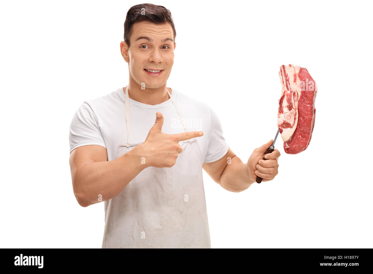 Smiling butcher holding a fork with a steak and pointing isolated on ...
