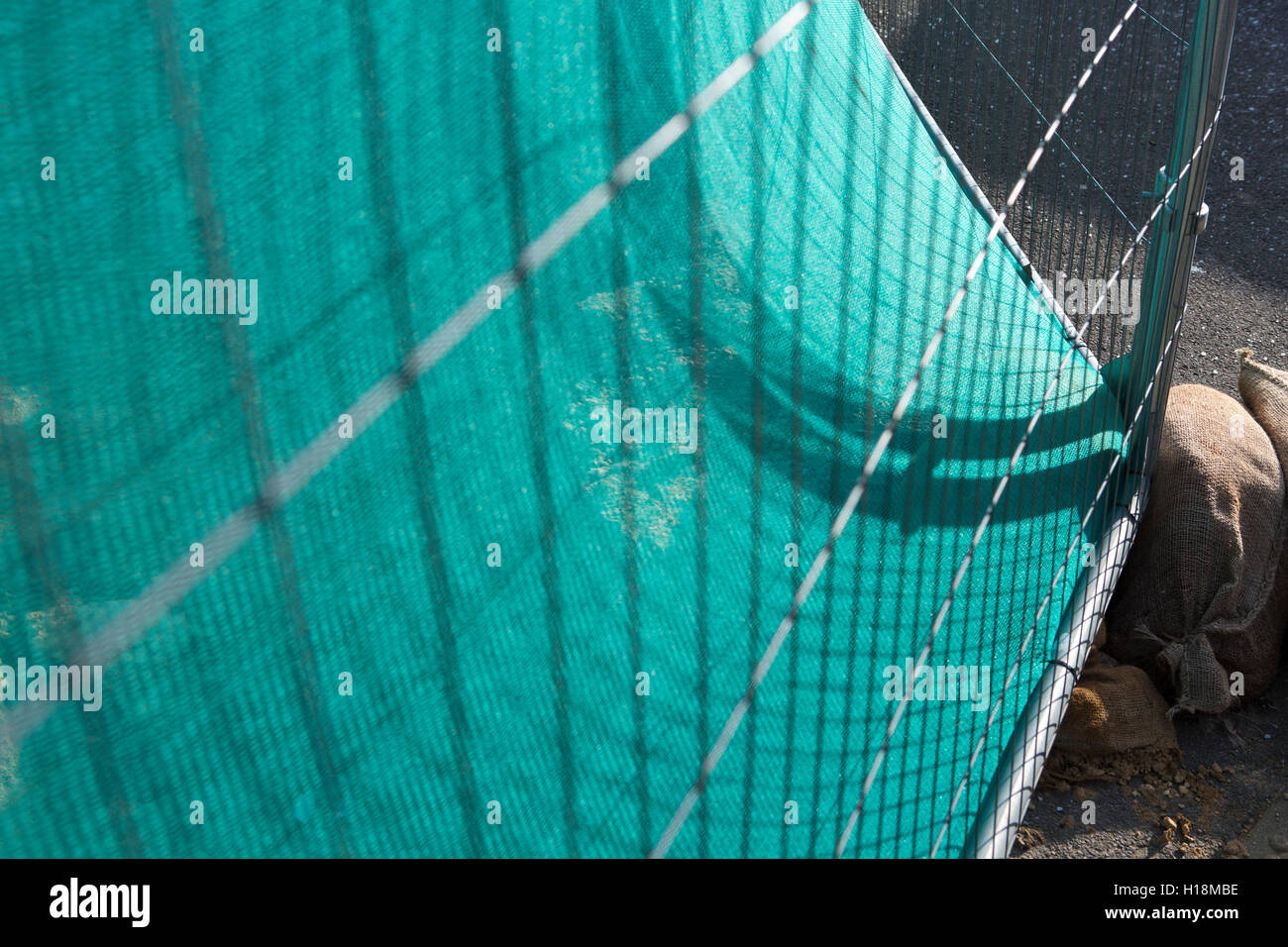 Green netting and metal framed security fence around a building site ...