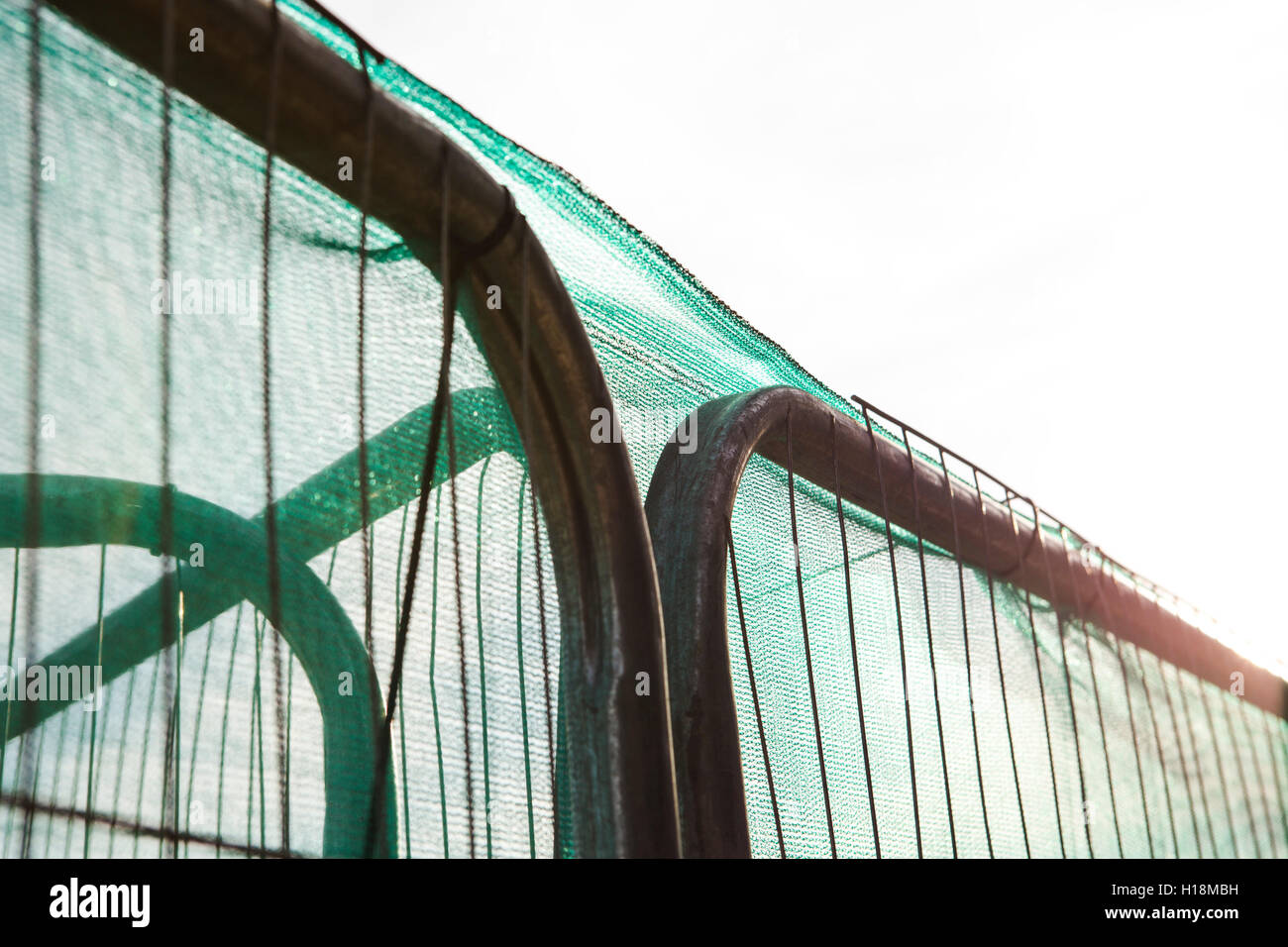 Green netting and metal framed security fence around a building site ...