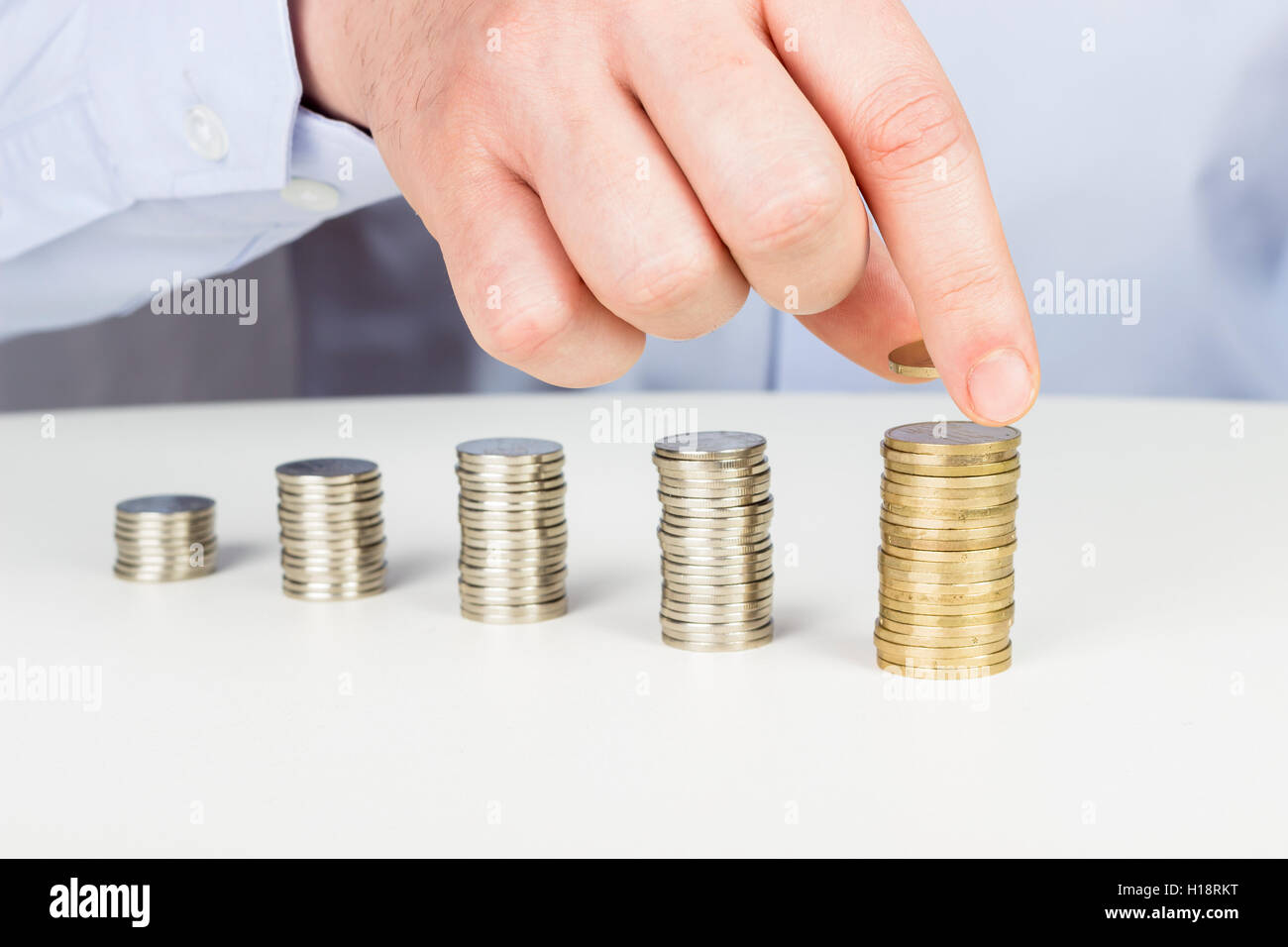Businessman stacking coins Stock Photo - Alamy