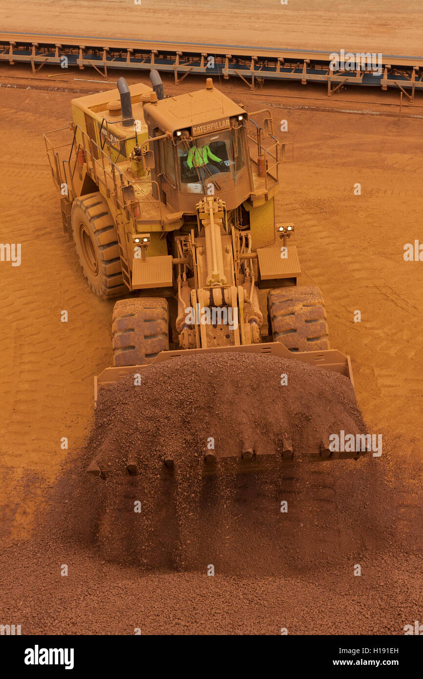 Front end loader loading hopper with lump iron ore from reclaimed stack ...