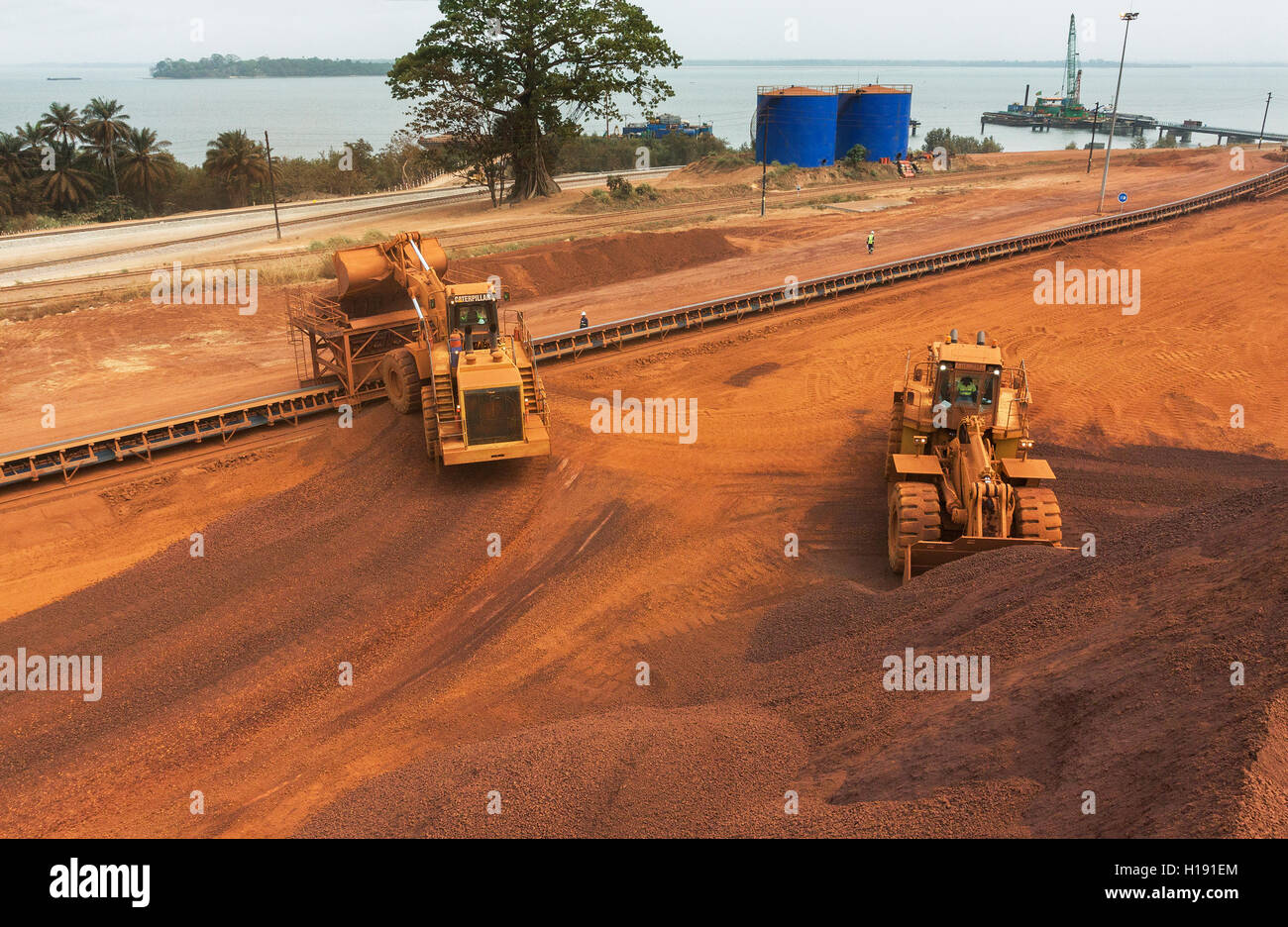 2 Front end loaders loading hopper with lump iron ore from reclaimed ...