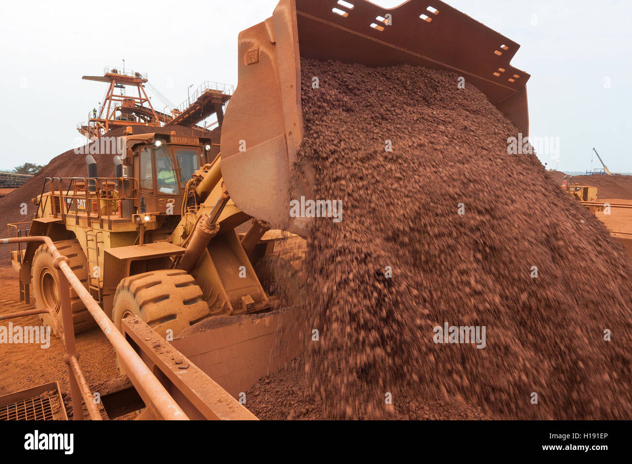 Front end loader loading hopper with lump iron ore from reclaimed stack ...