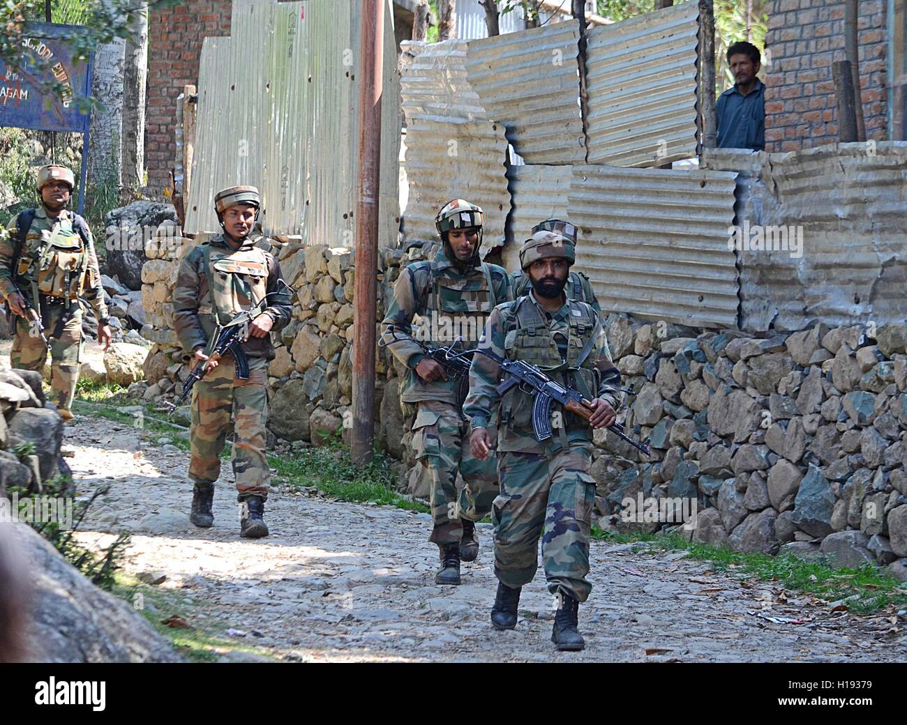 A Kashmiri Muslim looks from an alley as Indian army soldiers patrol ...