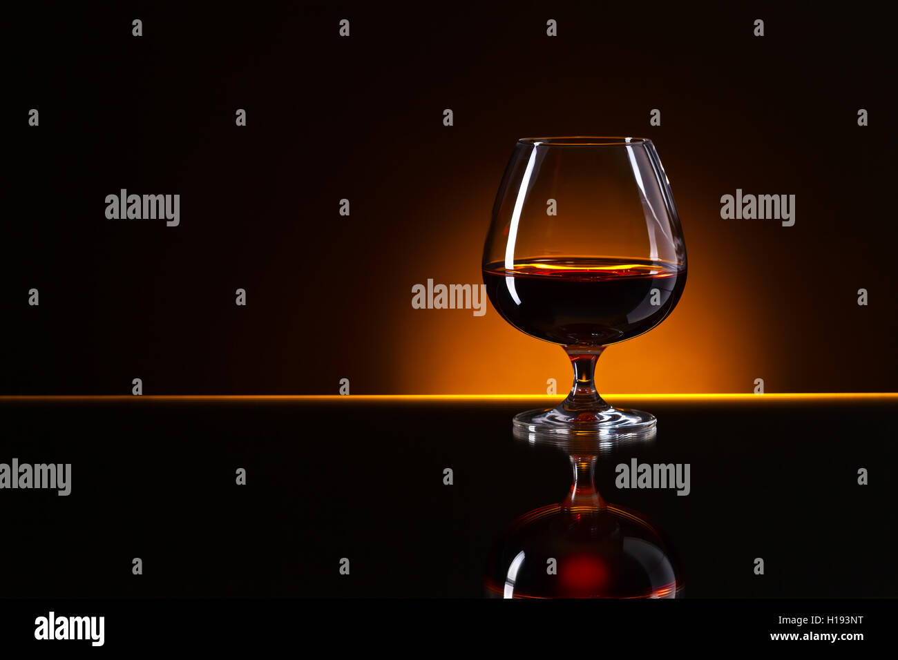 Snifter with brandy on a reflective background Stock Photo - Alamy