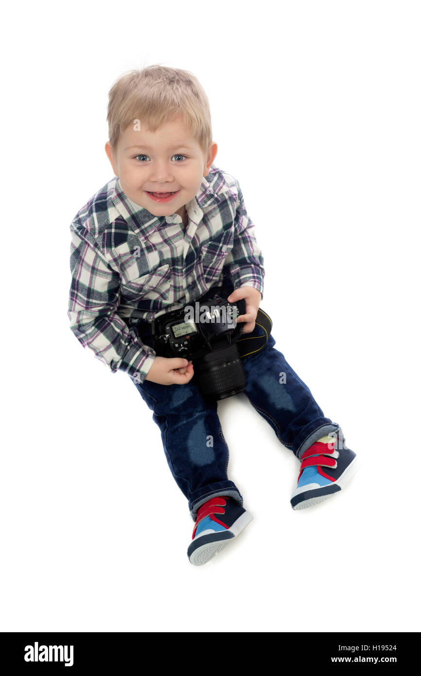 The three-year boy with a camera in hand sitting in the studio on a ...