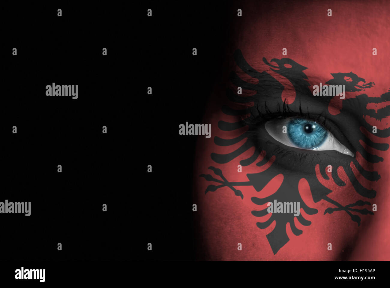 A young female with the flag of Albania painted on her face on her way ...