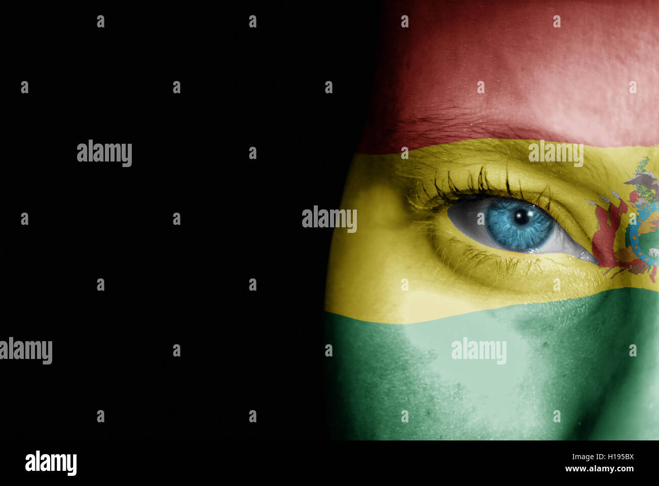 A young female with the flag of Bolivia painted on her face on her way ...