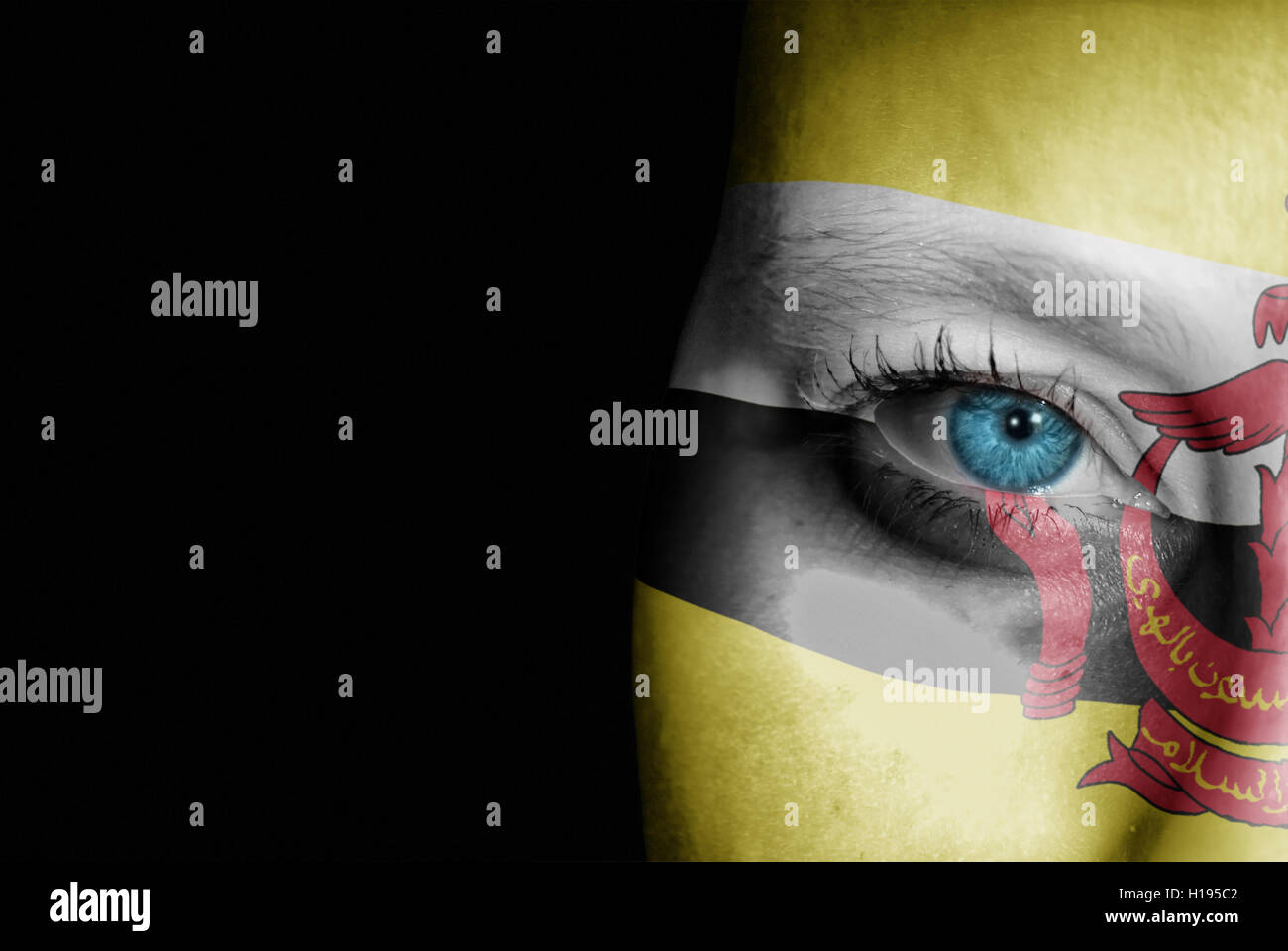 A young female with the flag of Brunei painted on her face on her way ...