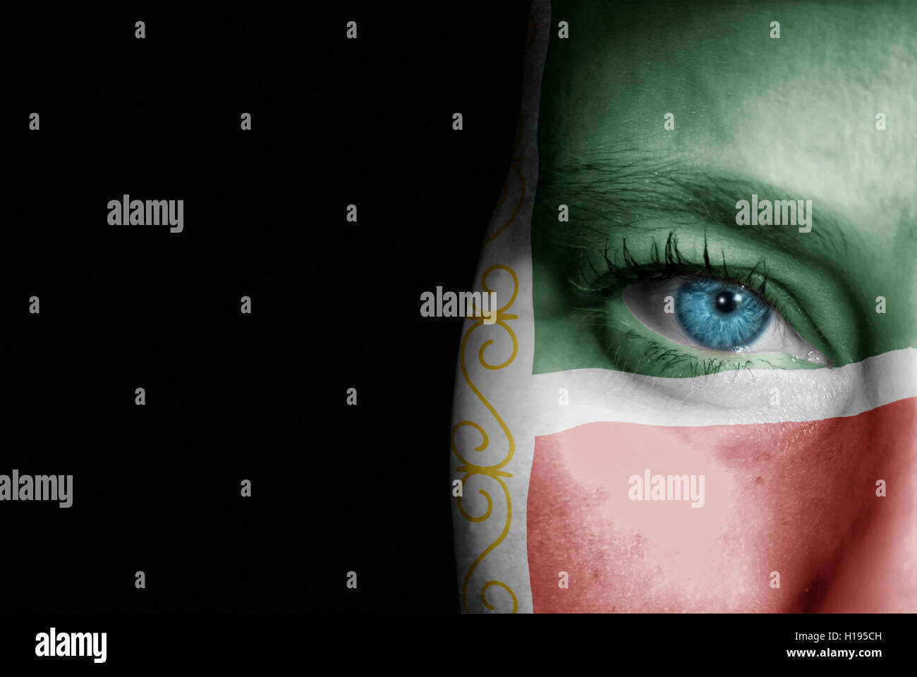 A young female with the flag of Chechen Republic painted on her face on ...