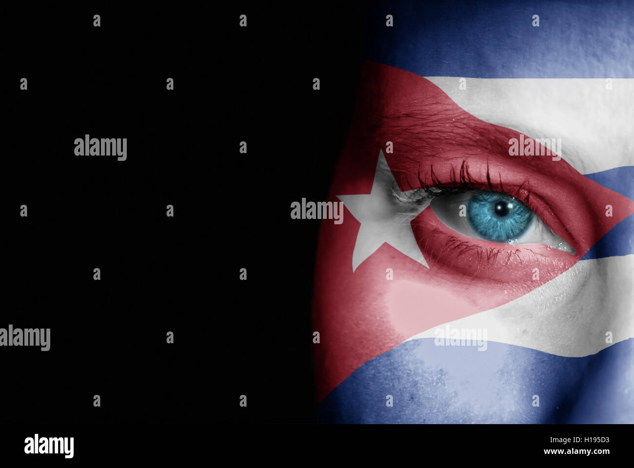 A young female with the flag of Cuba painted on her face on her way to ...