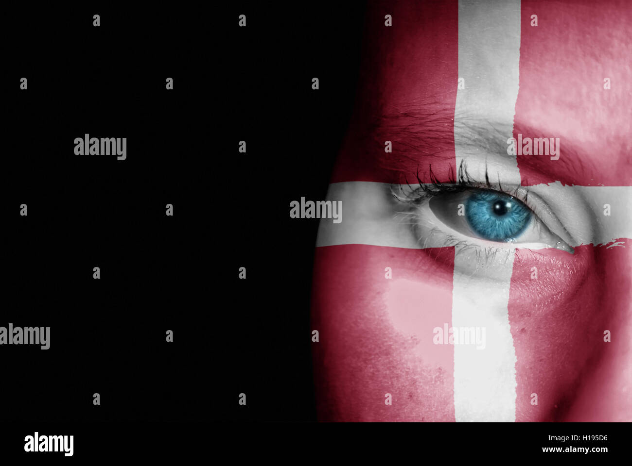 A young female with the flag of Denmark painted on her face on her way ...