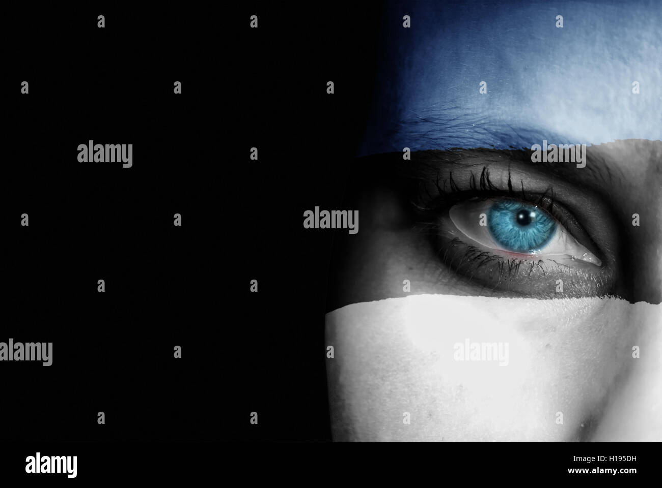 A young female with the flag of Estonia painted on her face on her way ...