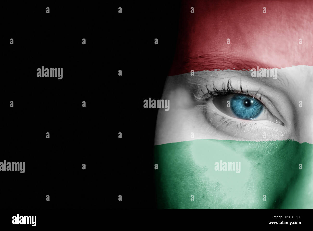 A young female with the flag of Hungary painted on her face on her way ...