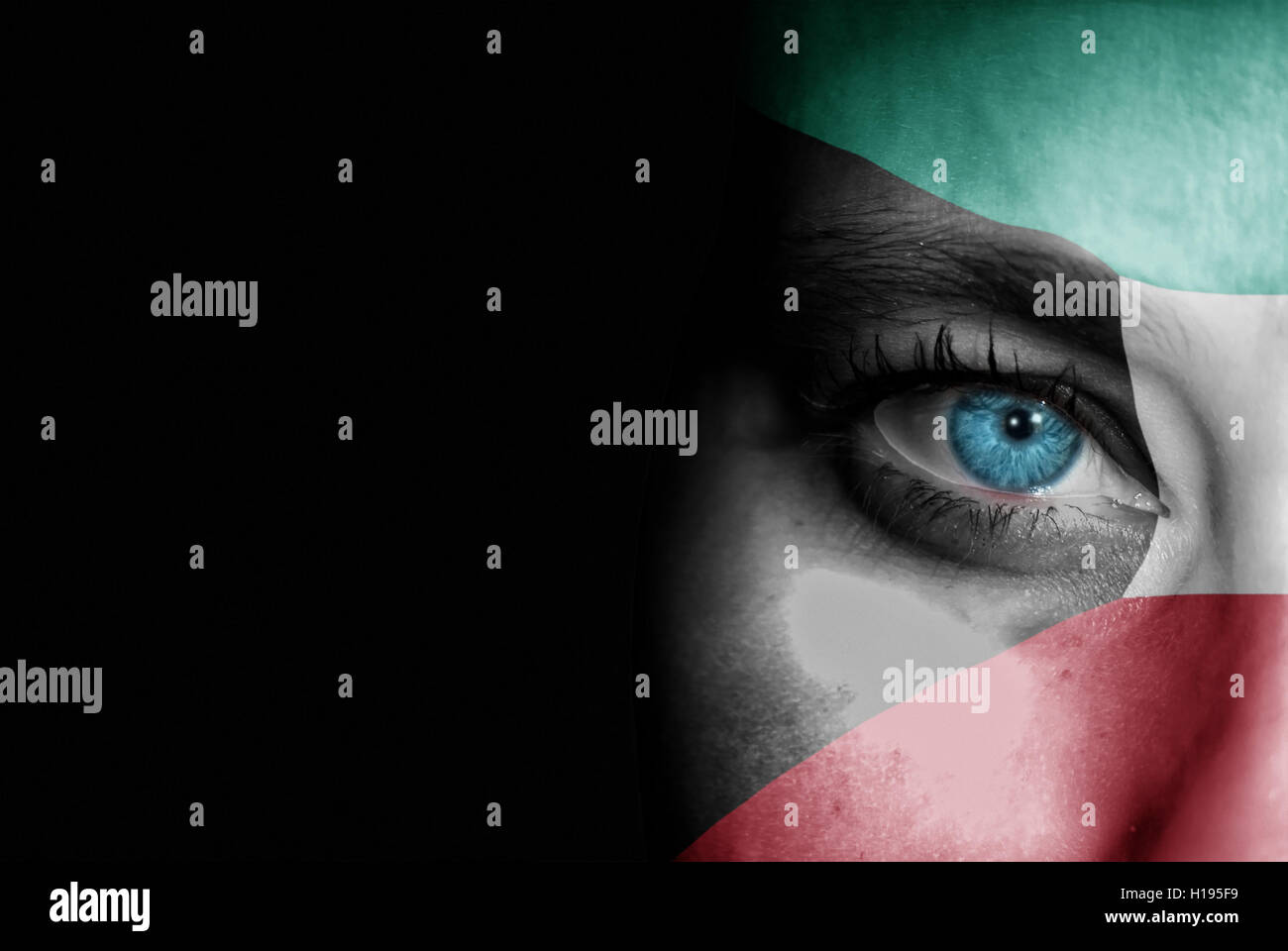 A young female with the flag of Kuwait painted on her face on her way ...
