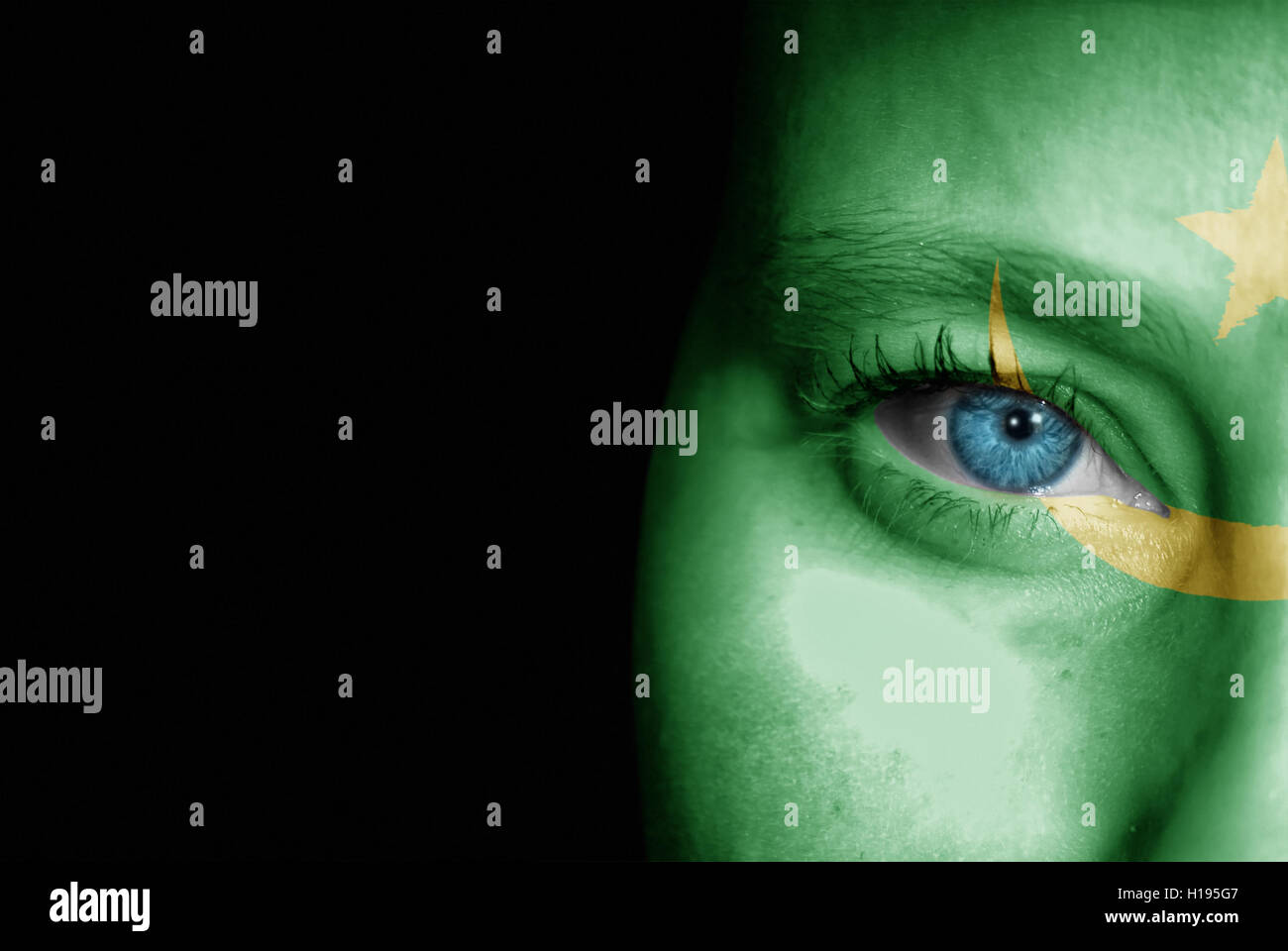 A young female with the flag of Mauritania painted on her face on her ...