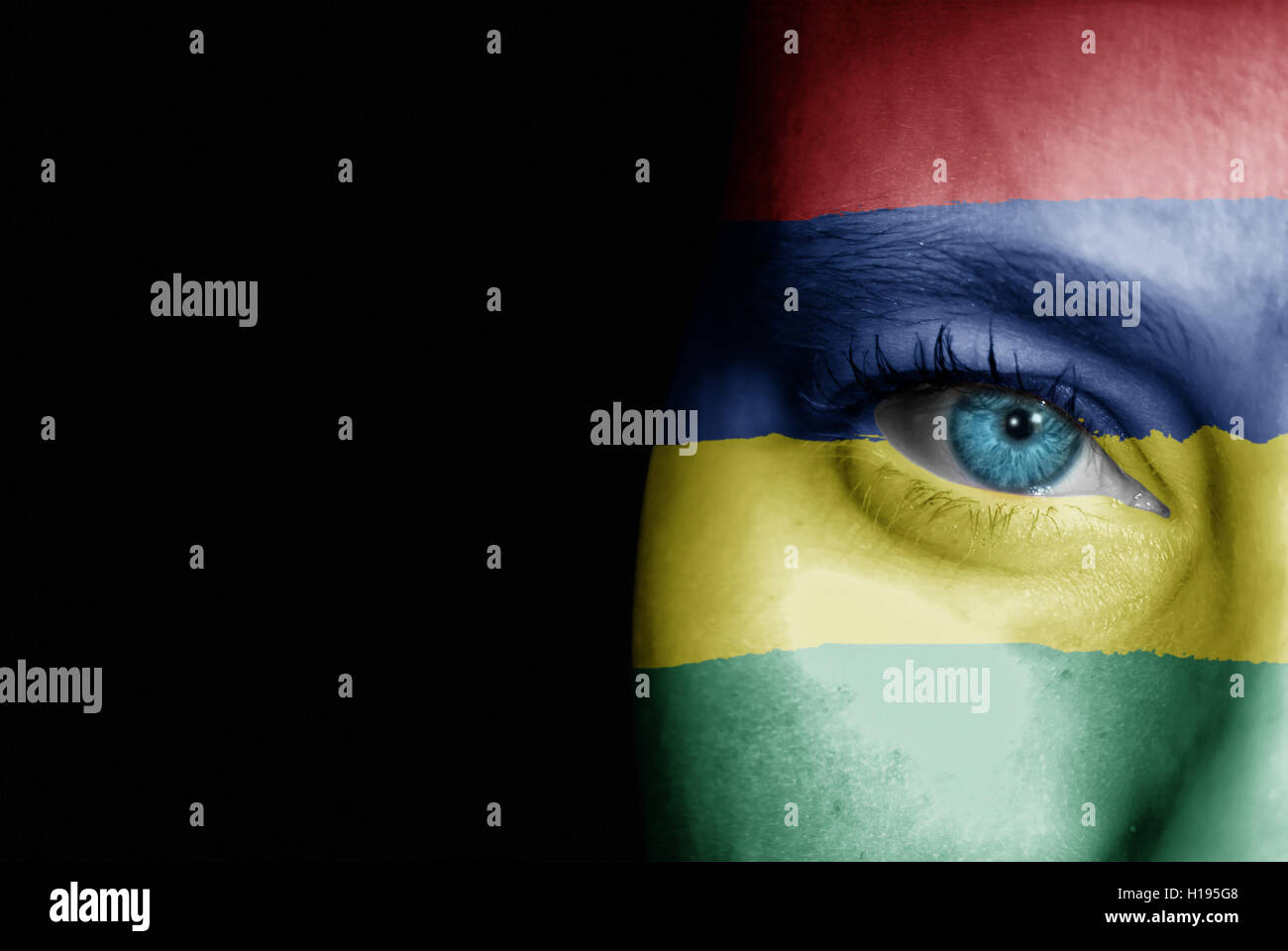 A young female with the flag of Mauritius painted on her face on her ...