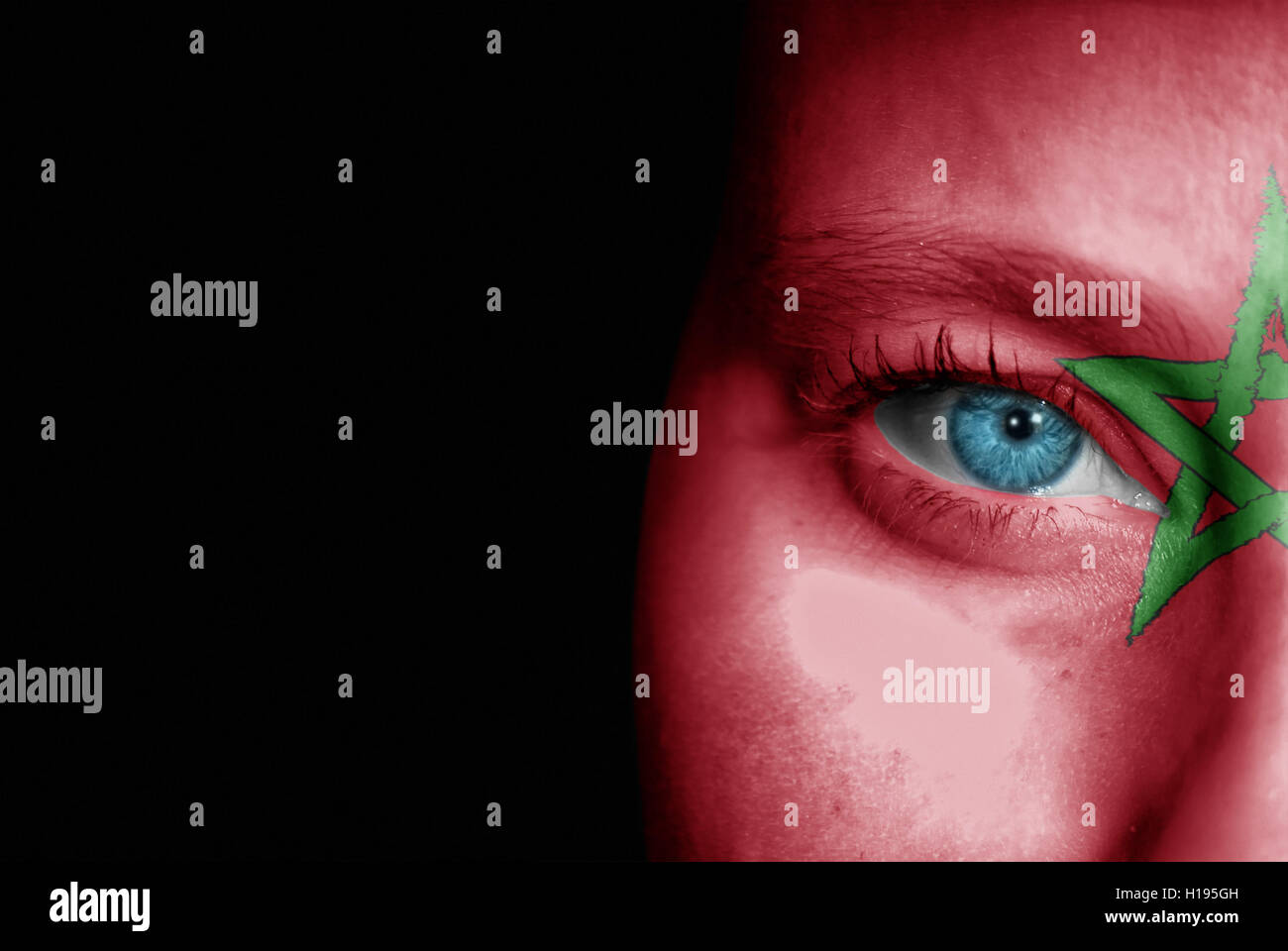 A young female with the flag of Morocco painted on her face on her way ...