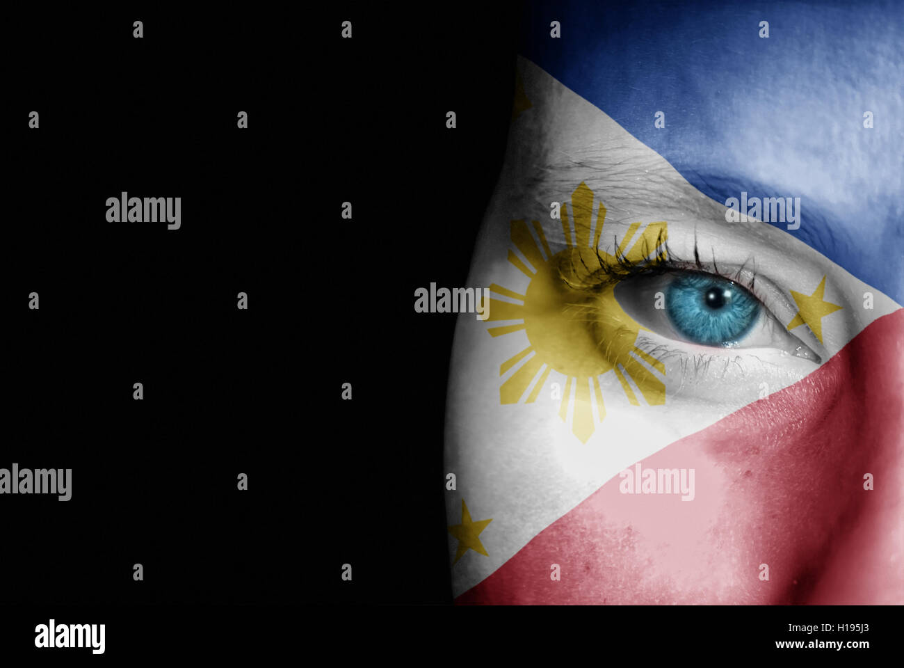 A young female with the flag of Philippines painted on her face on her ...
