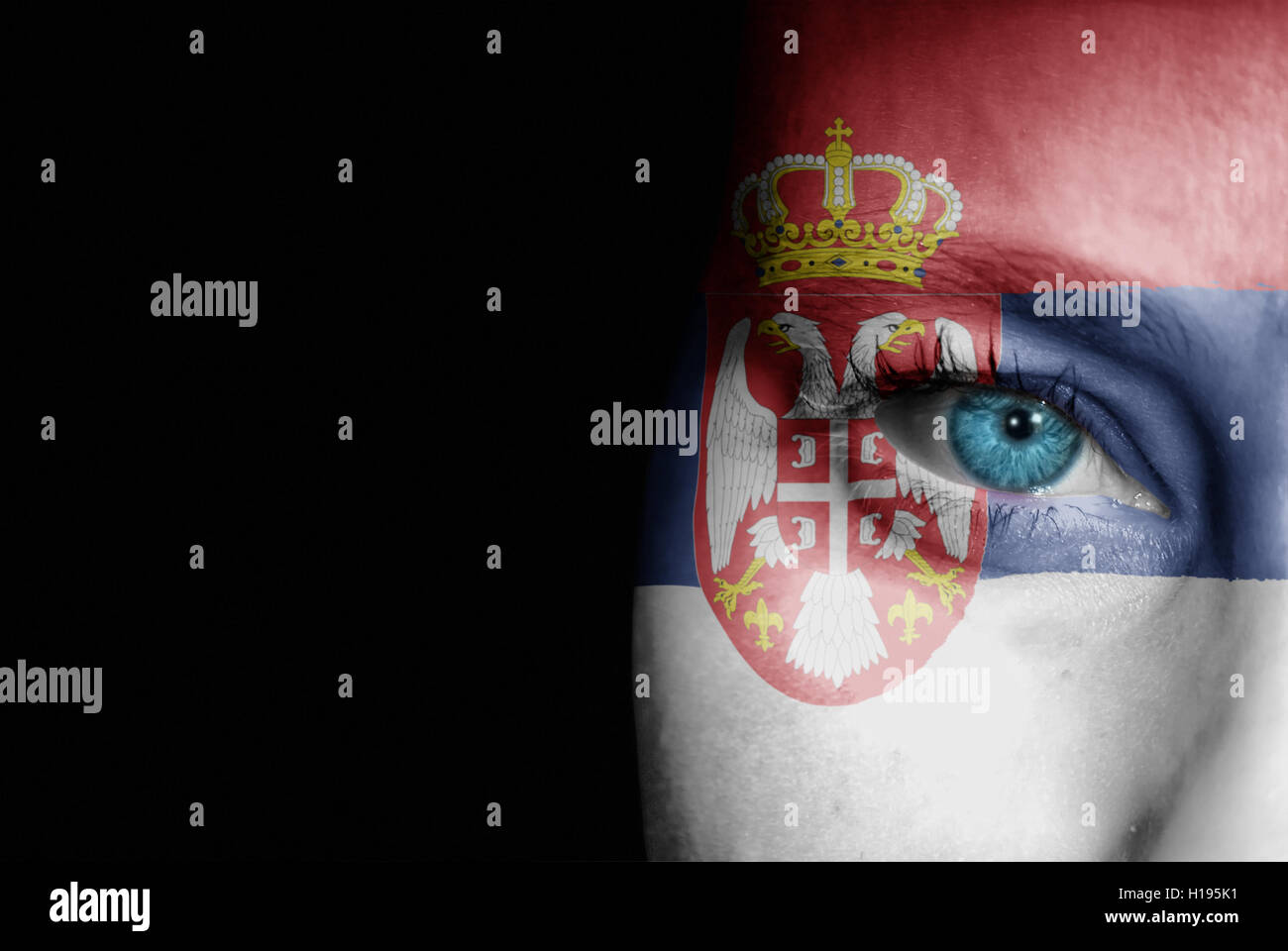 A young female with the flag of Serbia painted on her face on her way ...
